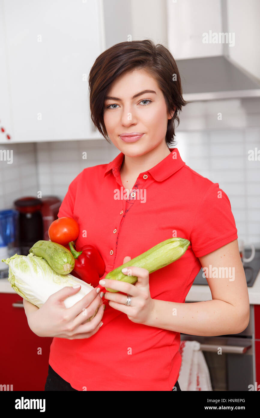 Girl with vegetables in hand in kitchen Stock Photo - Alamy