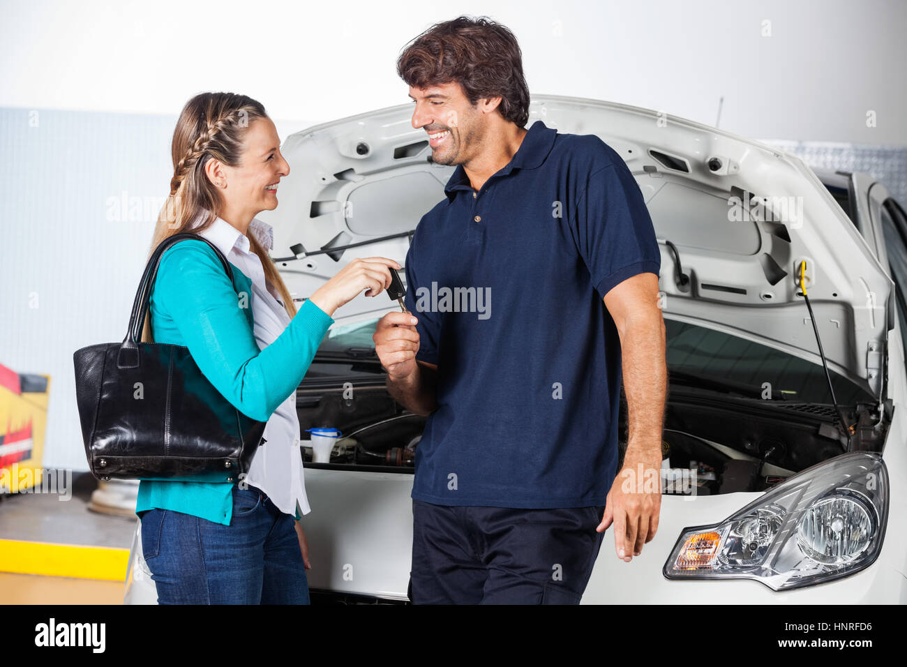 Happy Customer Giving Car Keys To Mechanic Stock Photo - Alamy