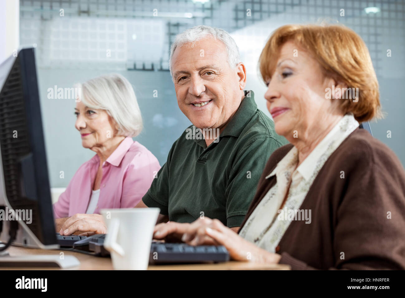 Confident Senior Man With Female Friends In Computer Class Stock Photo ...