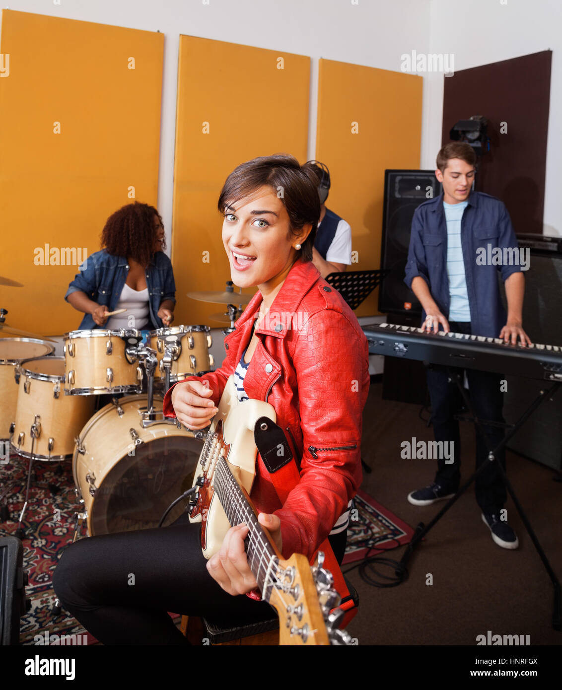 Female Guitarist Singing While Performing With Band Stock Photo - Alamy