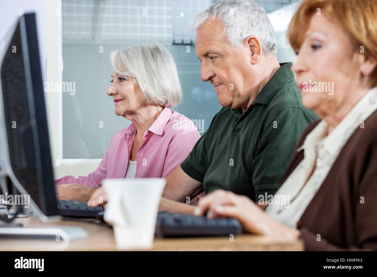 Senior Students Using Computers At Desk Stock Photo - Alamy