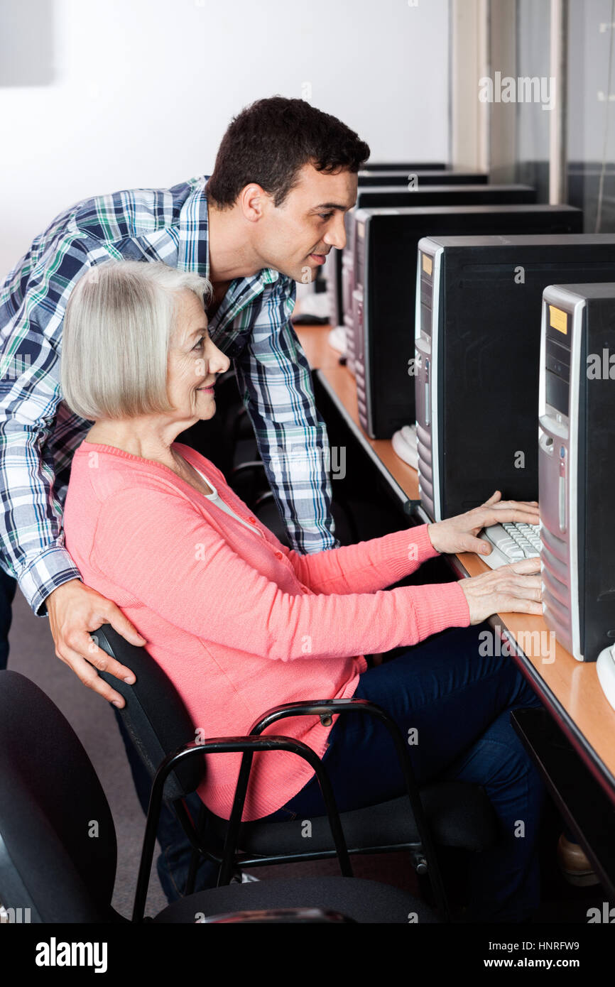 Teacher Helping Senior Woman In Using Computer Stock Photo - Alamy
