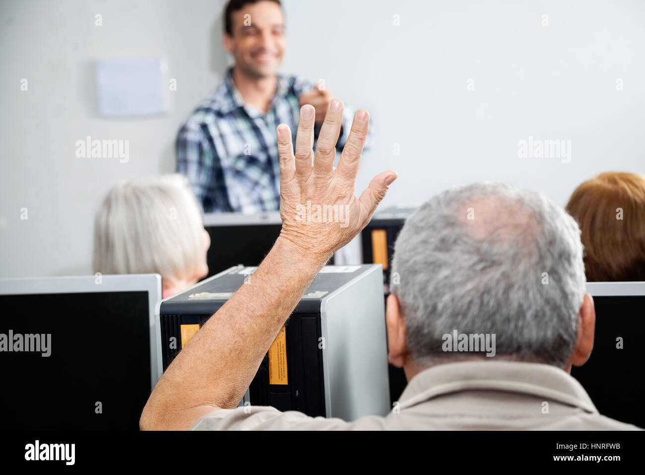 Senior Man Asking Question In Computer Class Stock Photo - Alamy