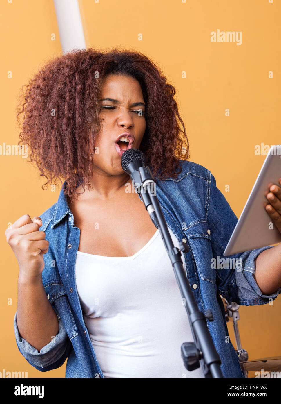 Passionate Singer Holding Tablet Computer While Performing Stock Photo ...