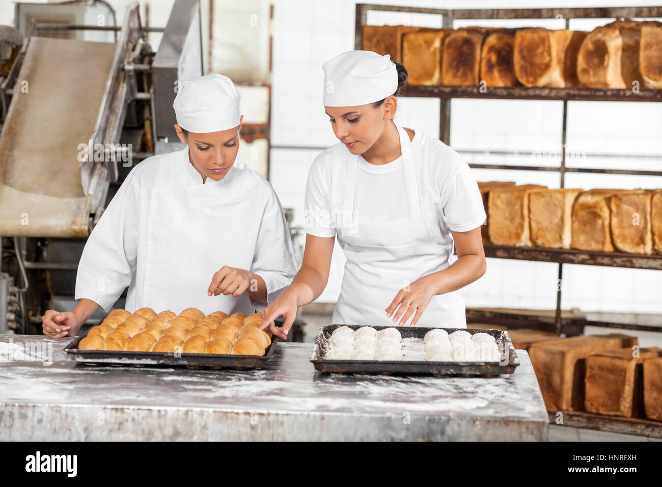 Female Colleagues Preparing Breads At Table Stock Photo - Alamy