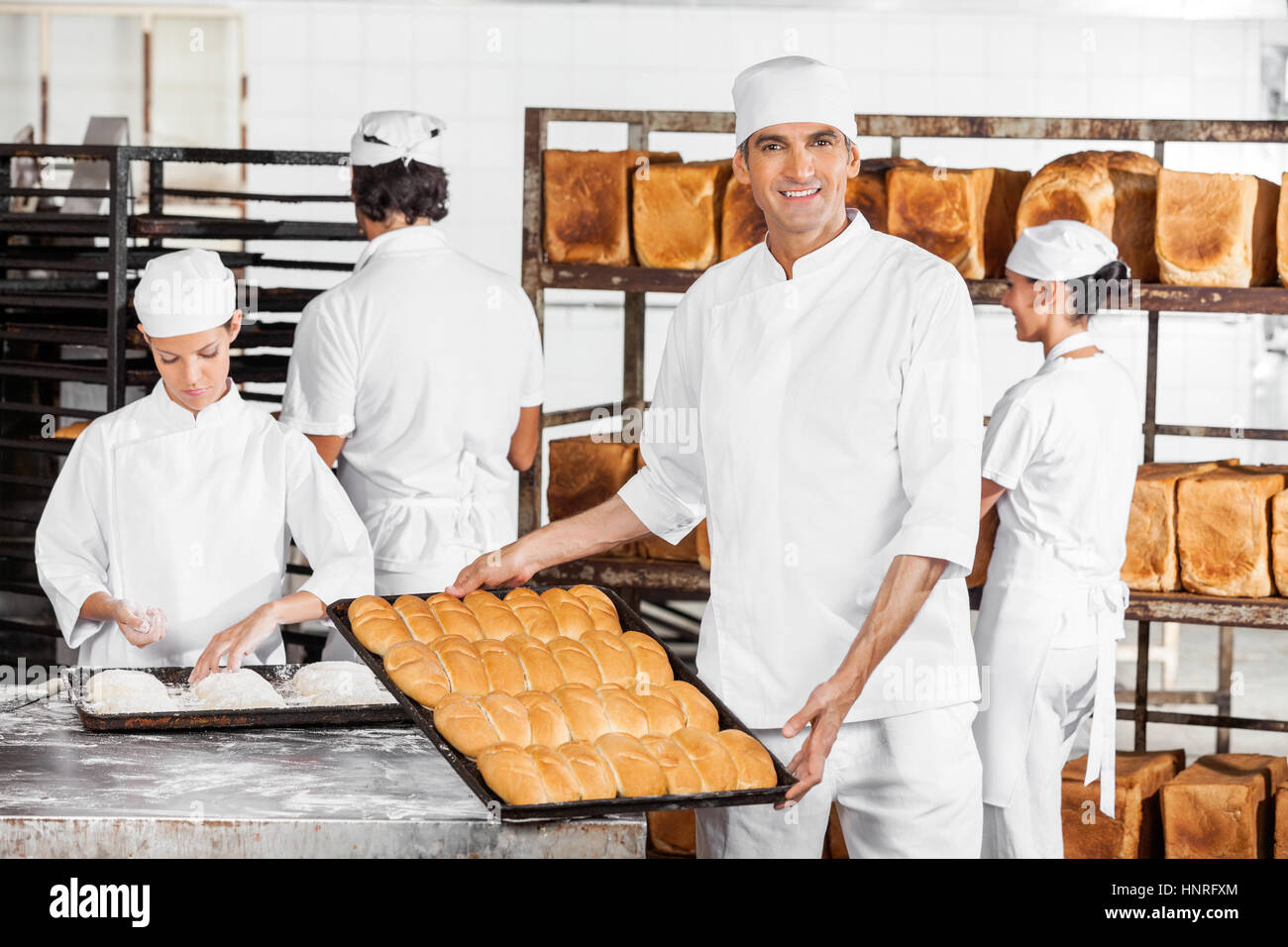 Confident Male Baker Showing Breads In Bakery Stock Photo - Alamy