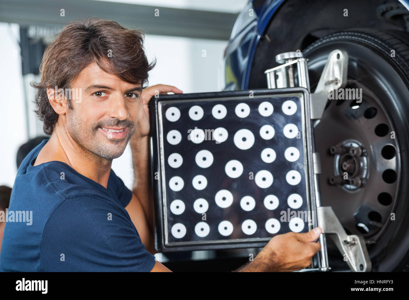 Confident Mechanic Adjusting Wheel Aligner On Car Stock Photo - Alamy