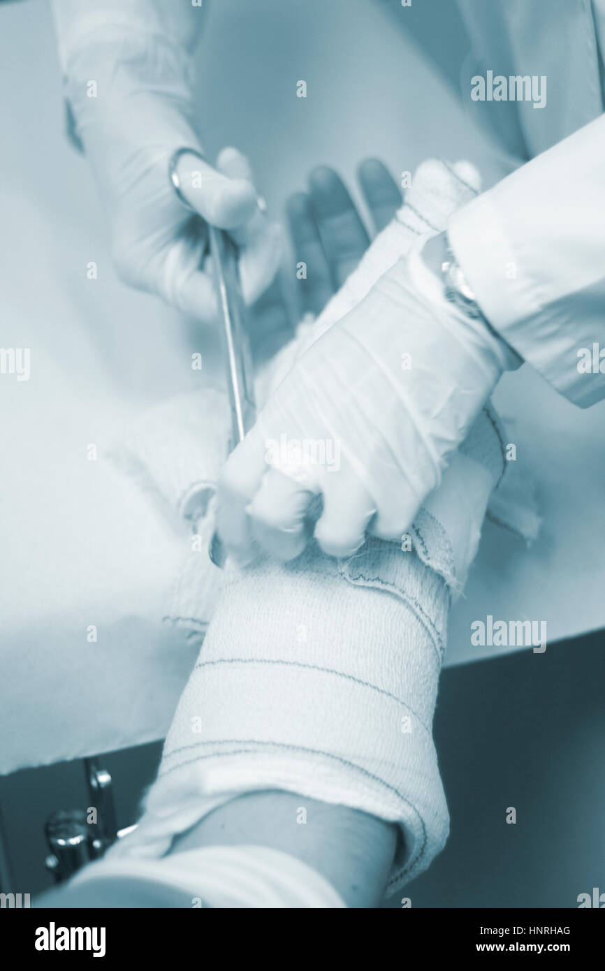 Doctor removing a plaster cast and bandages to patient forearm and ...