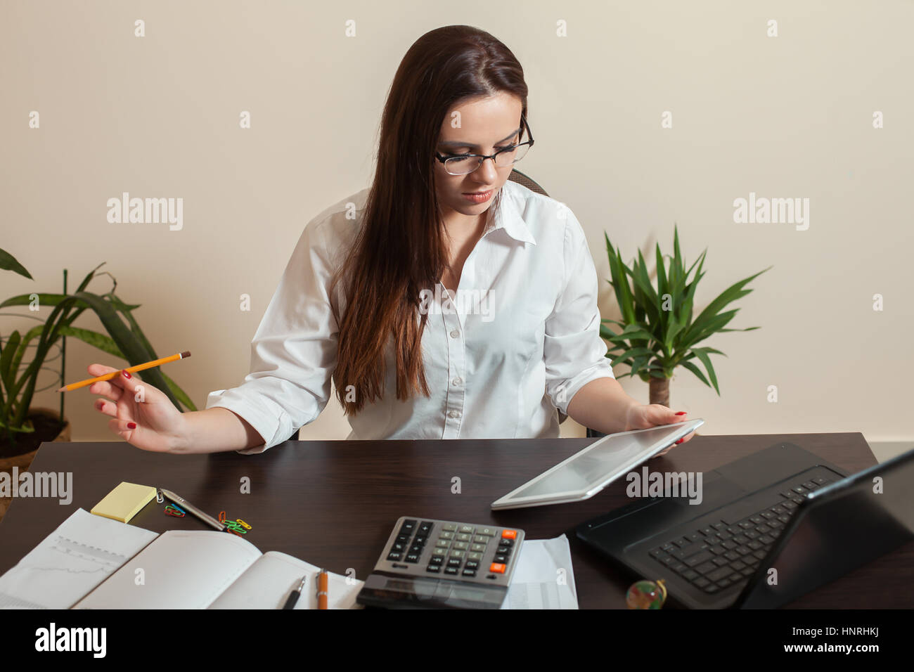 Female bookkeeper hands holding tablet pc. Table with laptop on ...