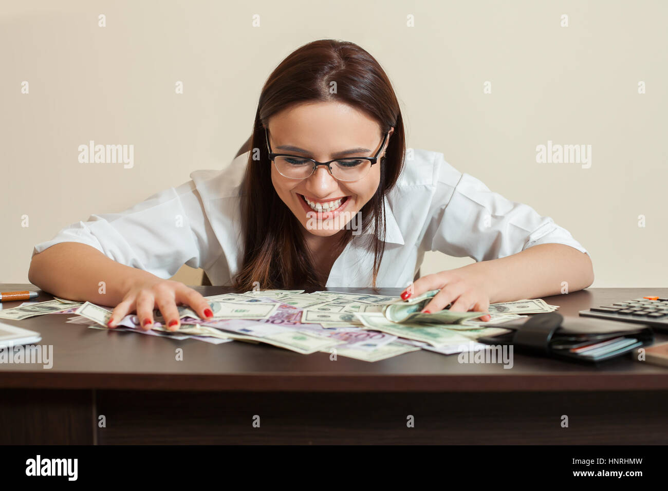 Happy business woman hugs a lot of money. Smiling young woman with ...