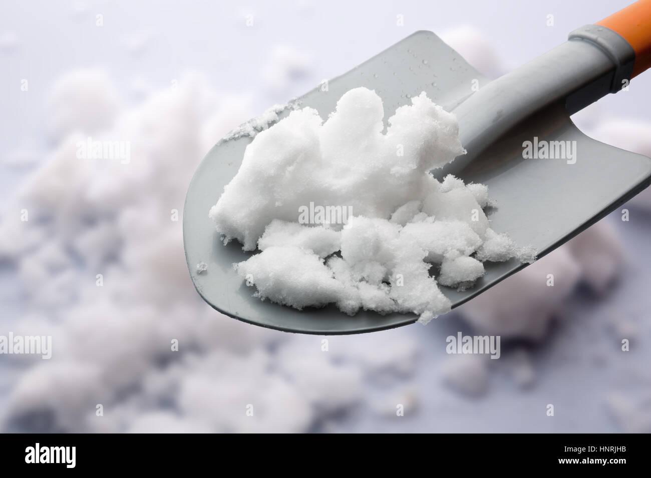Clean slush snow on shovel closeup, snowy background Stock Photo - Alamy