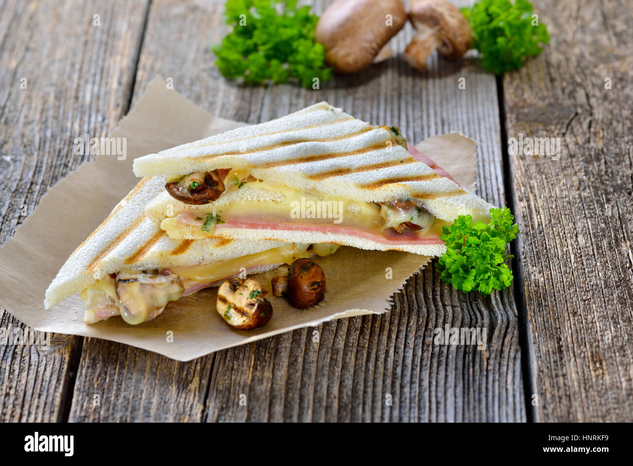 Pressed and toasted double panini with ham, cheese and mushrooms served ...