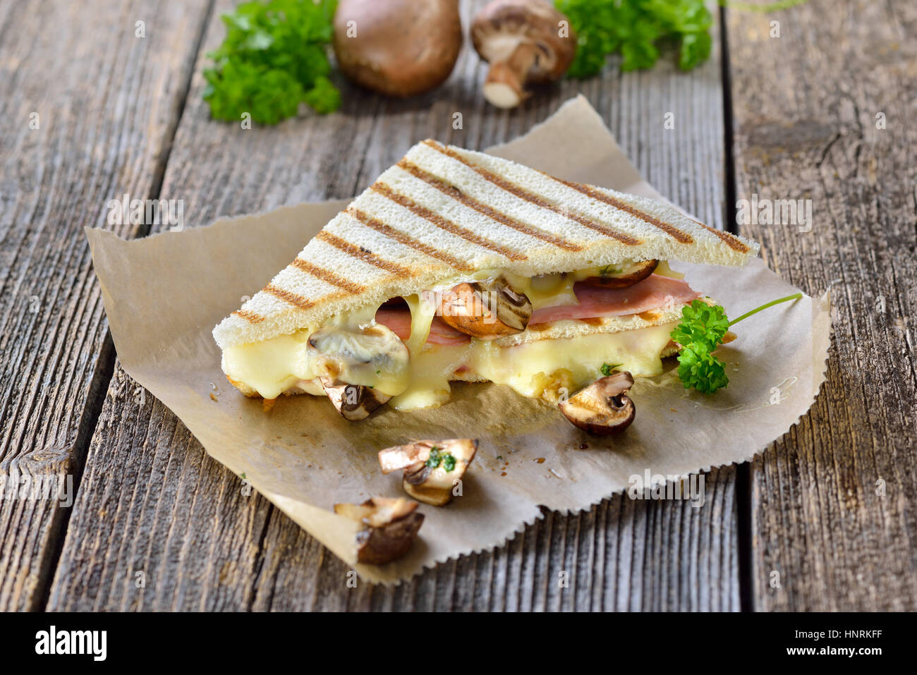 Pressed and toasted double panini with ham, cheese and mushrooms served ...