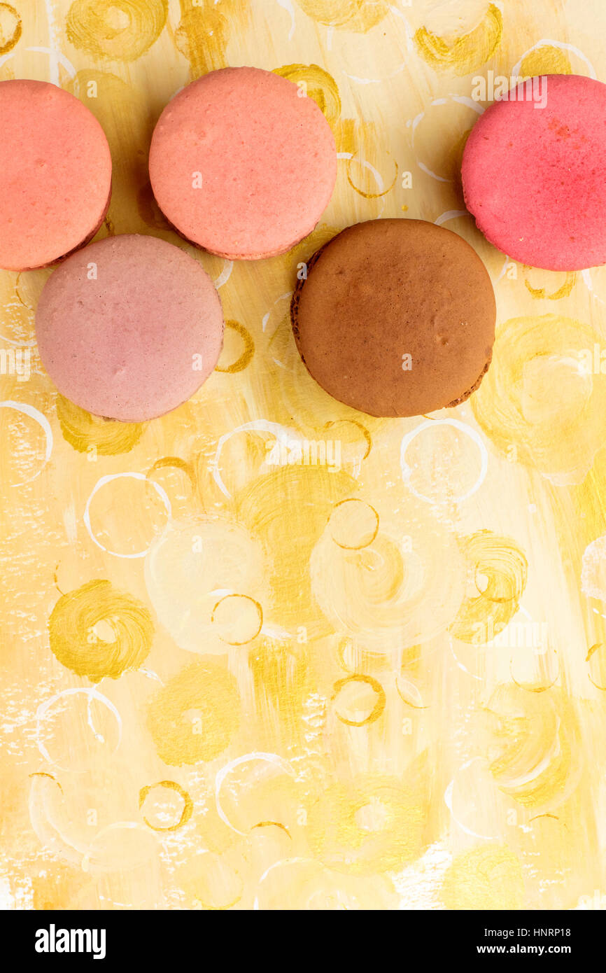 Pastel macarons on golden yellow texture Stock Photo - Alamy