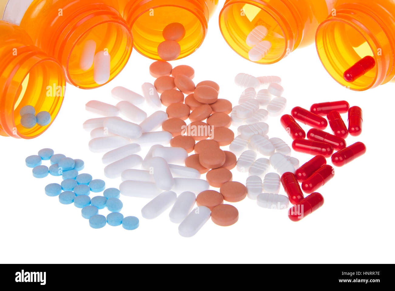 Five Prescription bottles lined up on their sides spilling medication ...