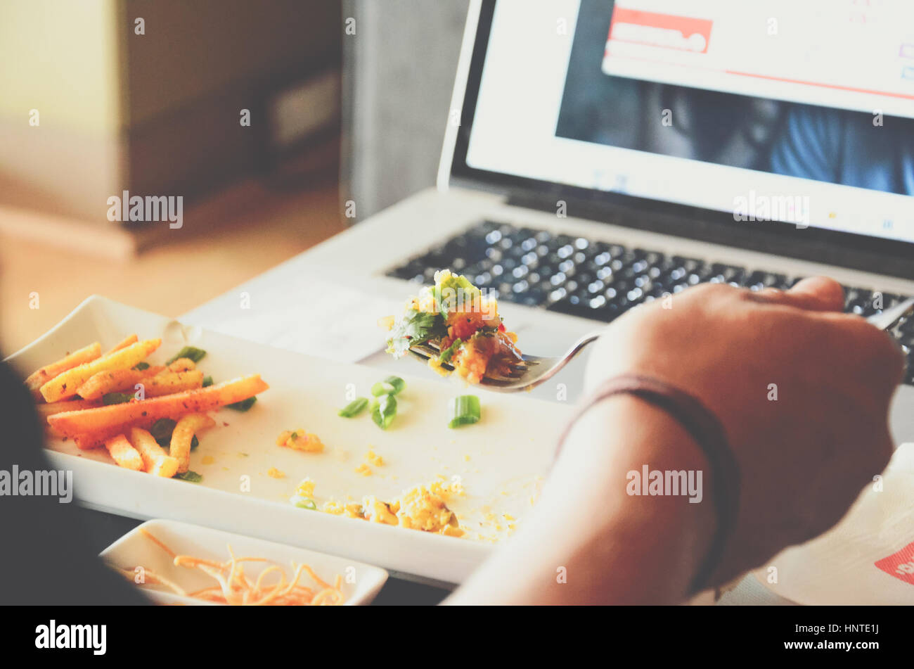 man eating in front of laptop Stock Photo - Alamy