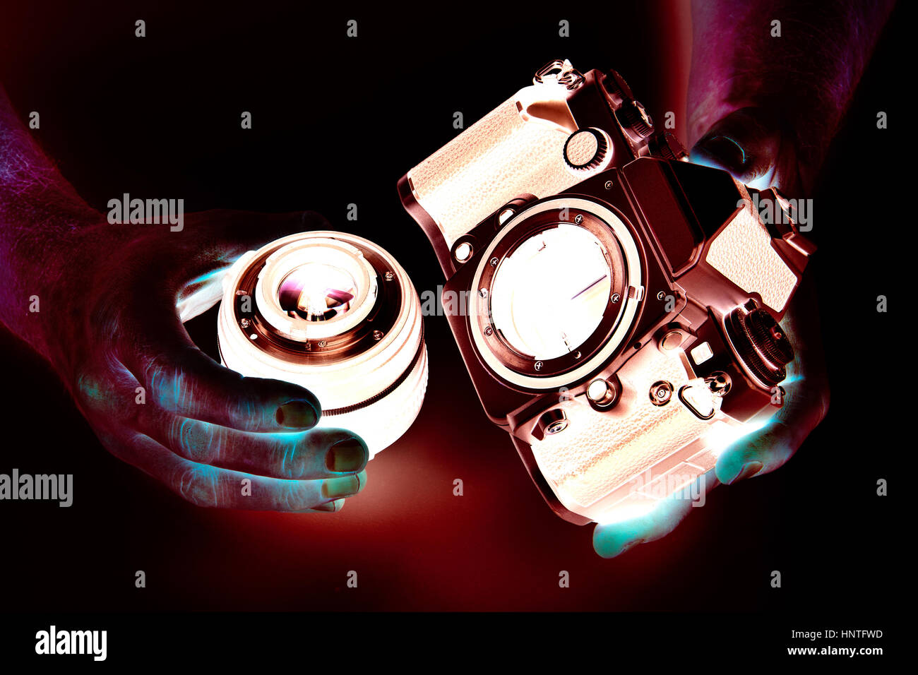 Negative photo of SLR camera in the hands of the photographer closeup ...