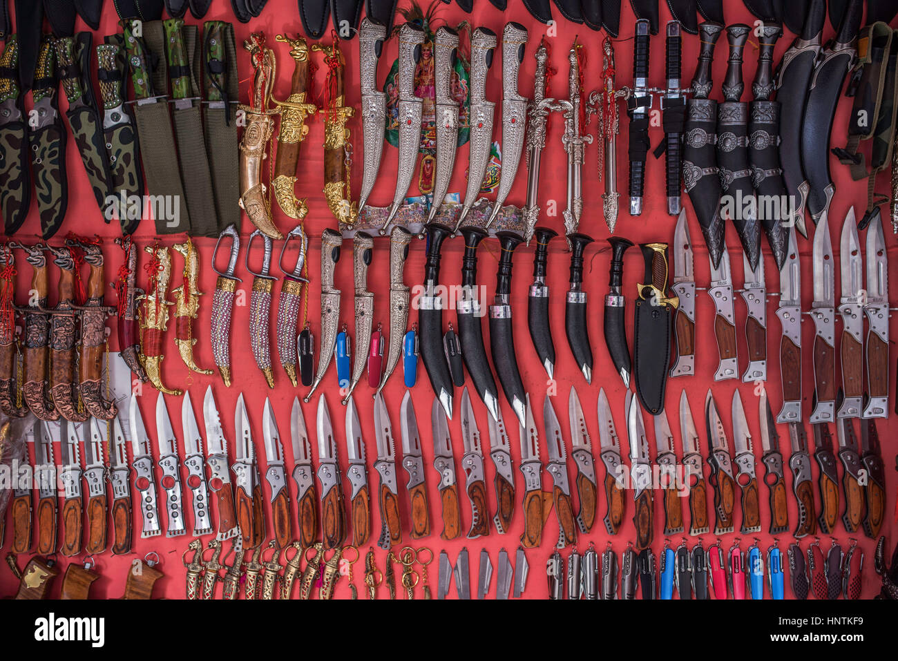 Knives on display on a red background for sale at pushkar, India Stock ...