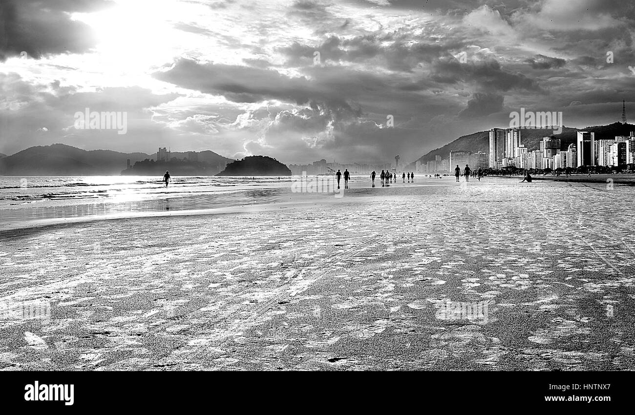 Silver Beach. A beach during sunset with people walking in the sand ...