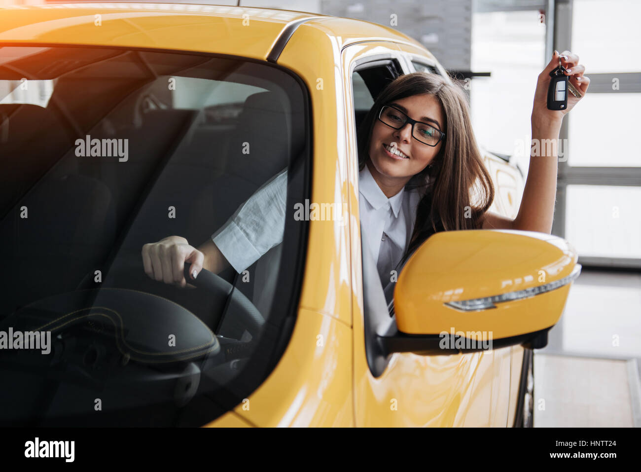 The woman driver smiling showing new car keys Stock Photo - Alamy
