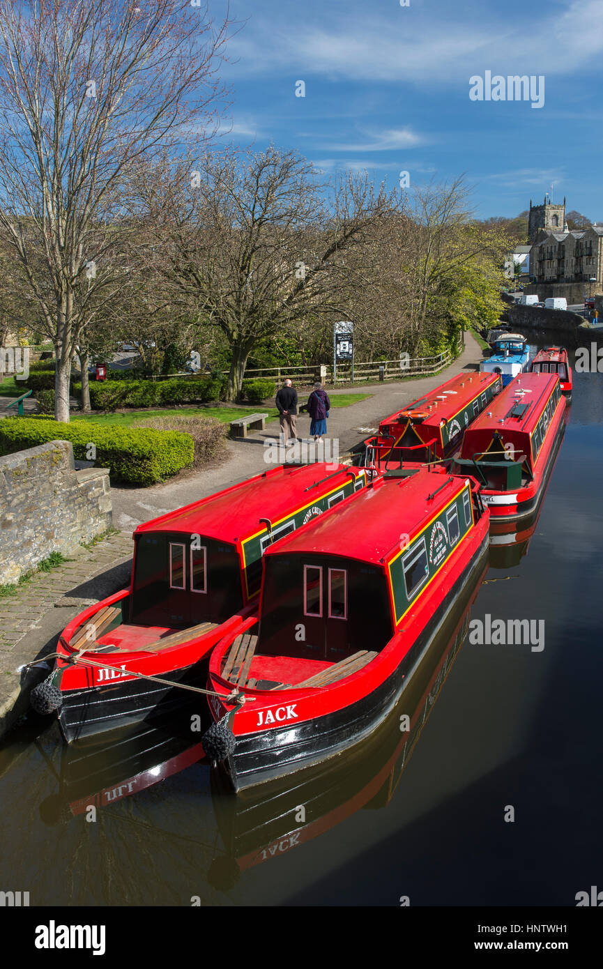 Scenic sunny high view of people walking on towpath past bright red ...