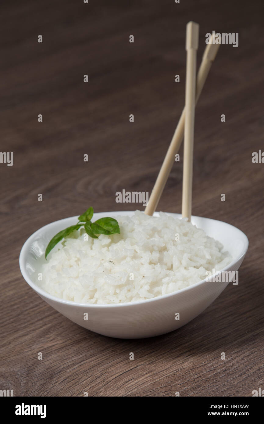 White rice in ceramic bow with wooden sticks Stock Photo - Alamy