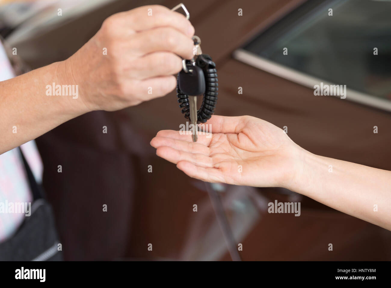 people's hand give and get car key with brown car background Stock ...