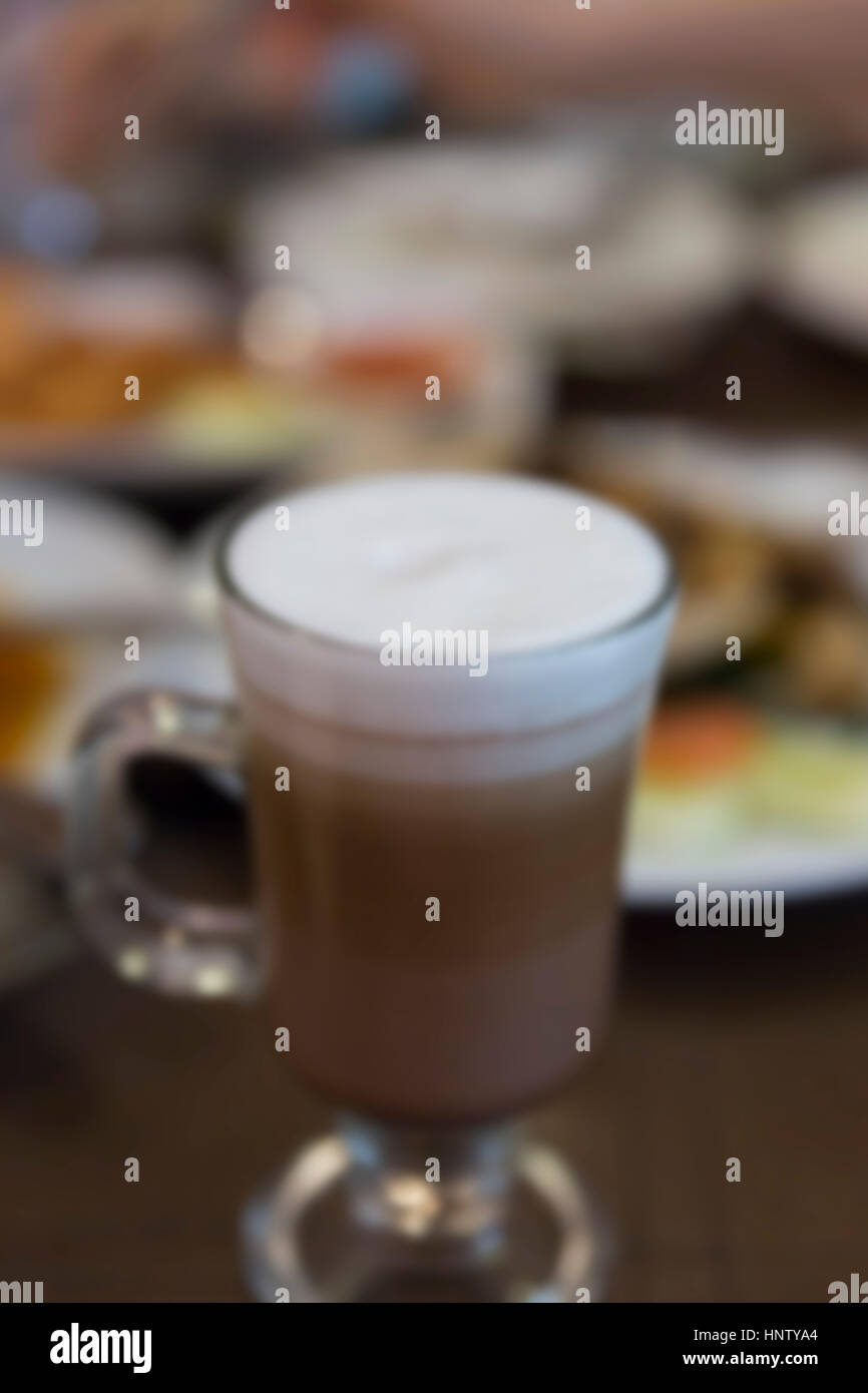 cup of hot frothy cappuccino coffee with bokeh light, blur background ...