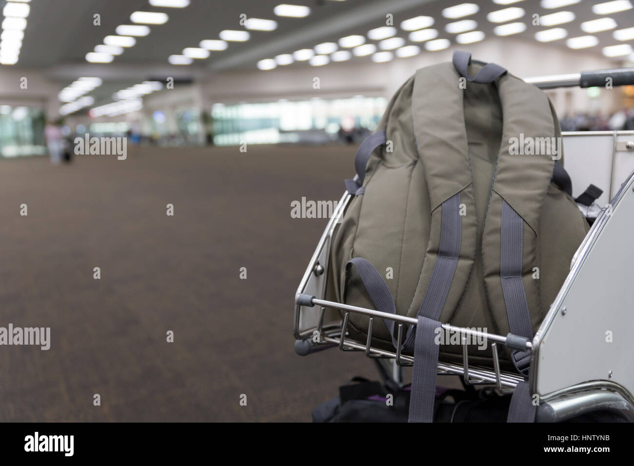 brown rucksack on trolley cart in airport terminal building for travel ...
