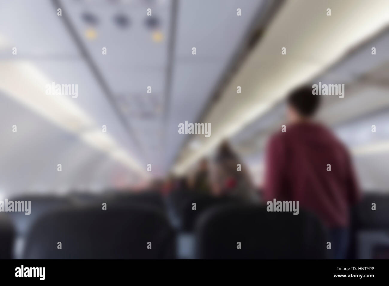 passenger walking in aisle in airplane cabin, blur background Stock ...