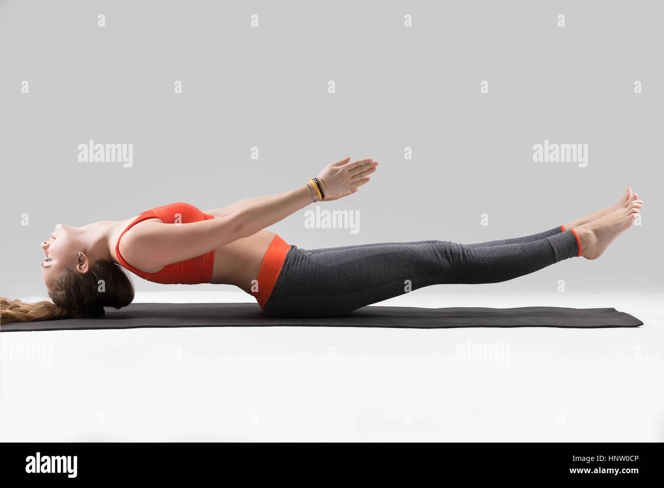 Young attractive woman stretching in Matsyasana pose, grey studi Stock ...
