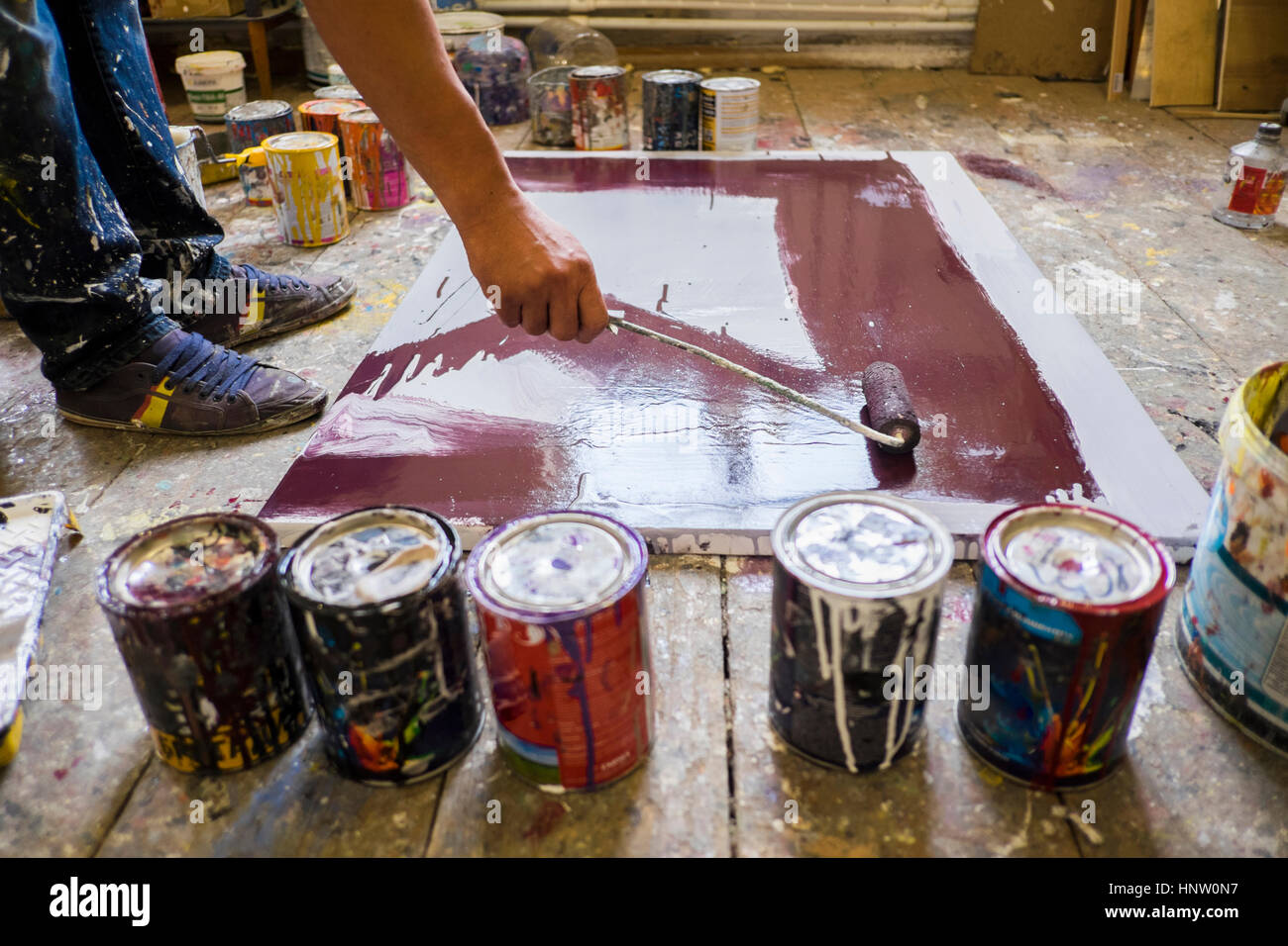 Legs of Mari man painting canvas on floor Stock Photo - Alamy