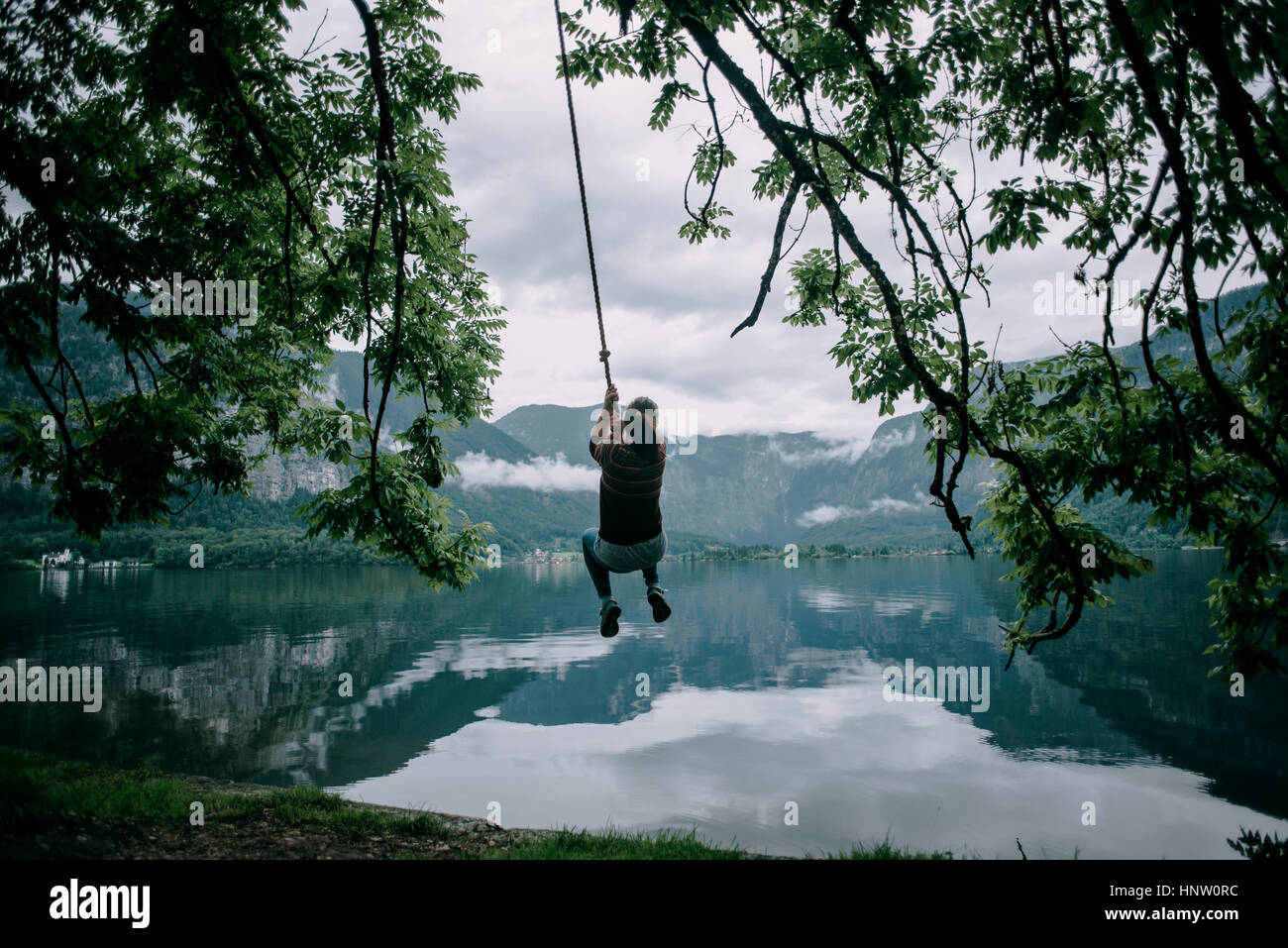 Caucasian woman swinging on rope swing at lake Stock Photo - Alamy