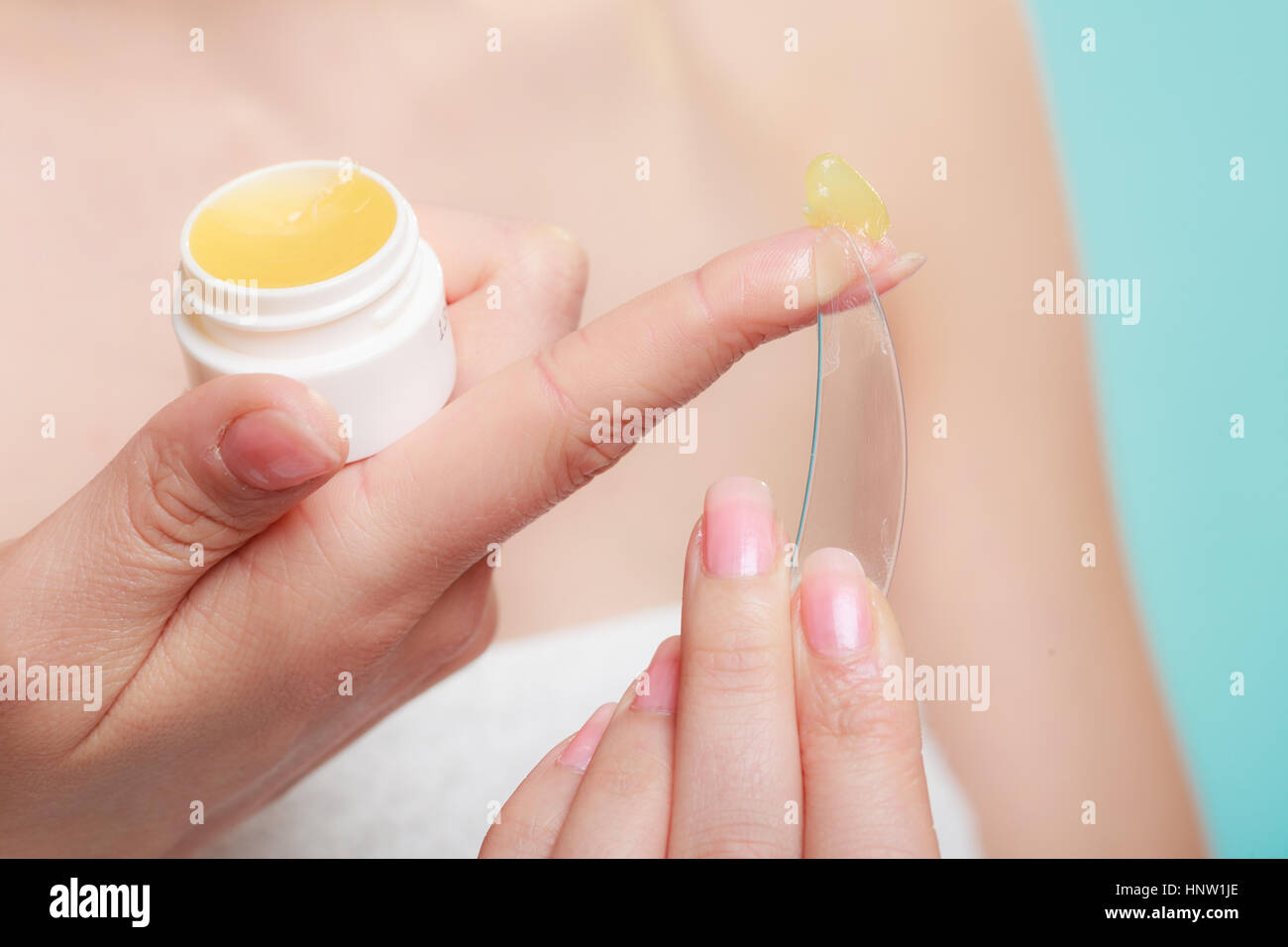Beauty, cosmetics, concept. Woman hand about to apply yellow face cream ...