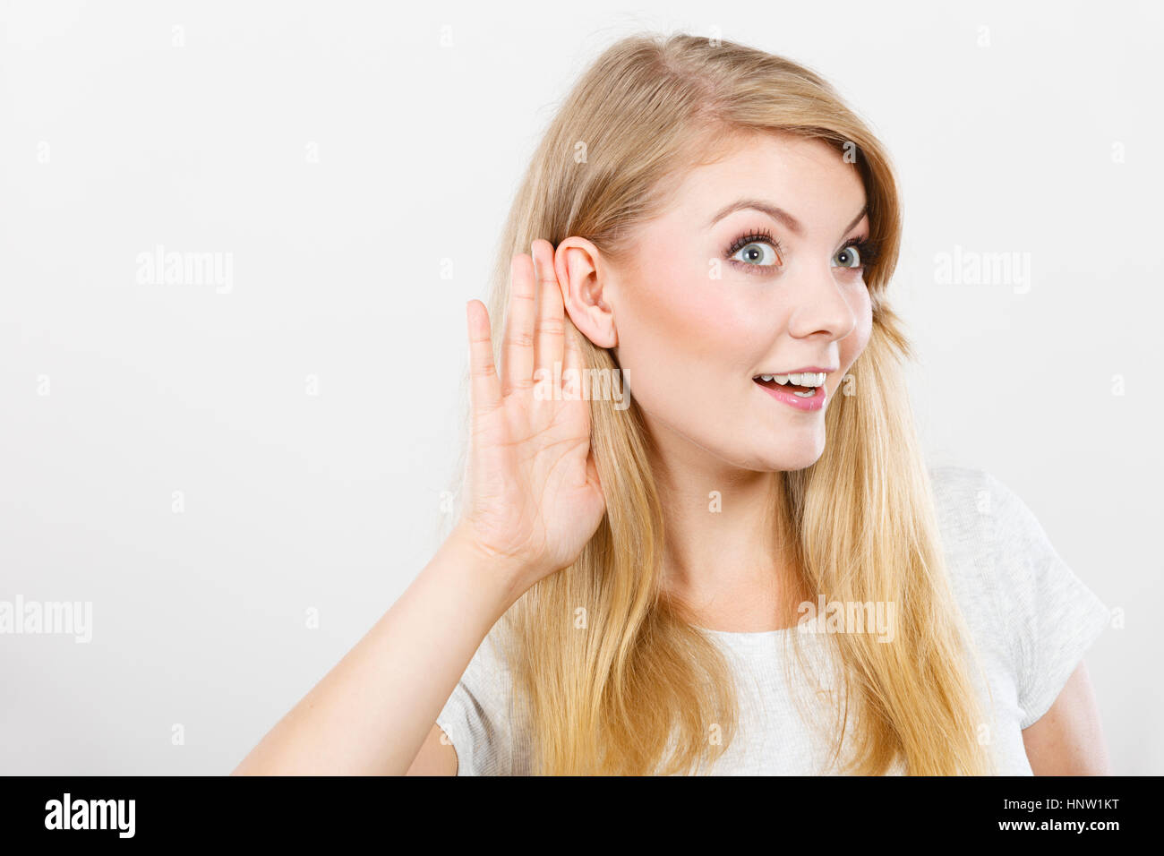 Gossip,rumors, whisper, hearing concept. Young blonde Woman putting ...