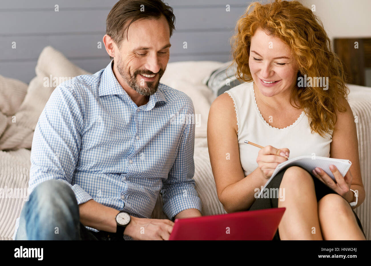 Smiling positive couple working together at home Stock Photo - Alamy