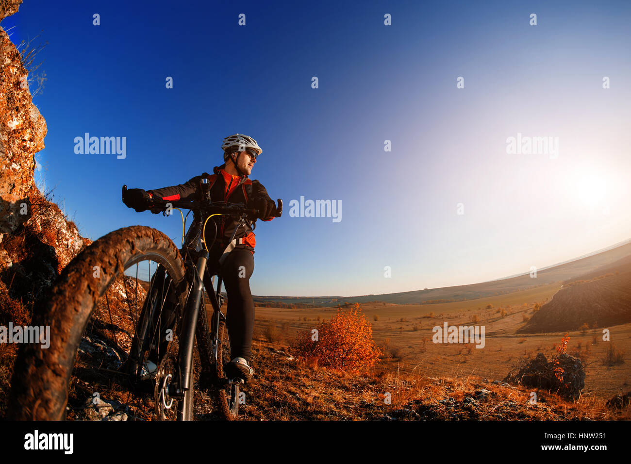 low angle view of cyclist riding mountain bike on rocky trail at ...