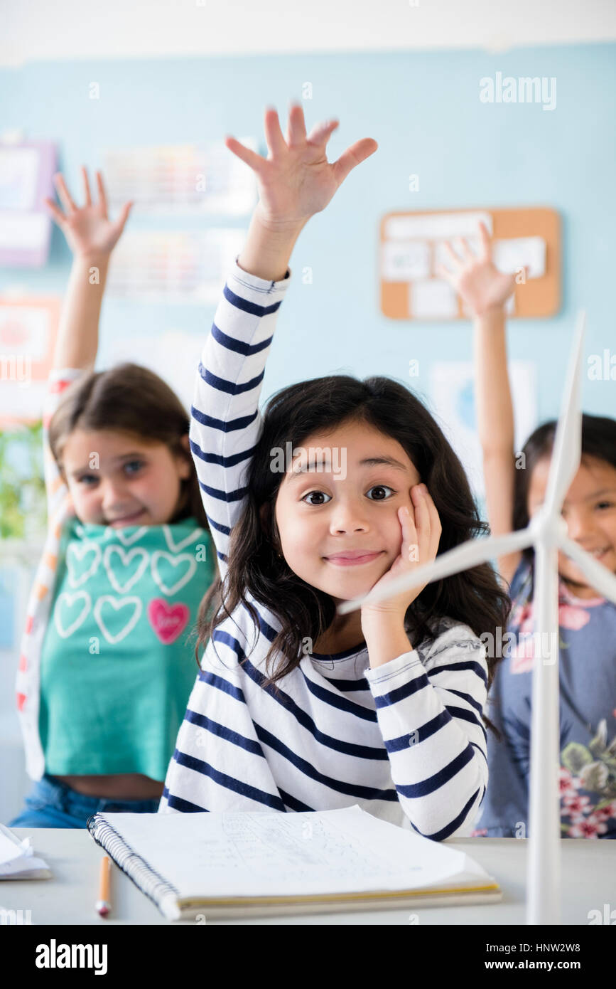 Girls learning about windmills raising hands in classroom Stock Photo ...