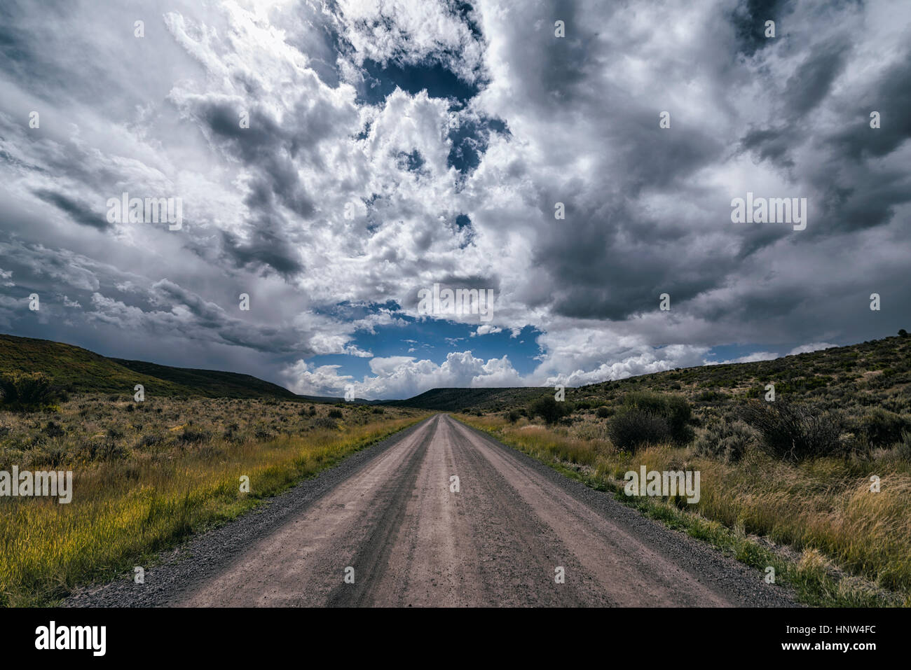 Remote dirt road under clouds Stock Photo - Alamy
