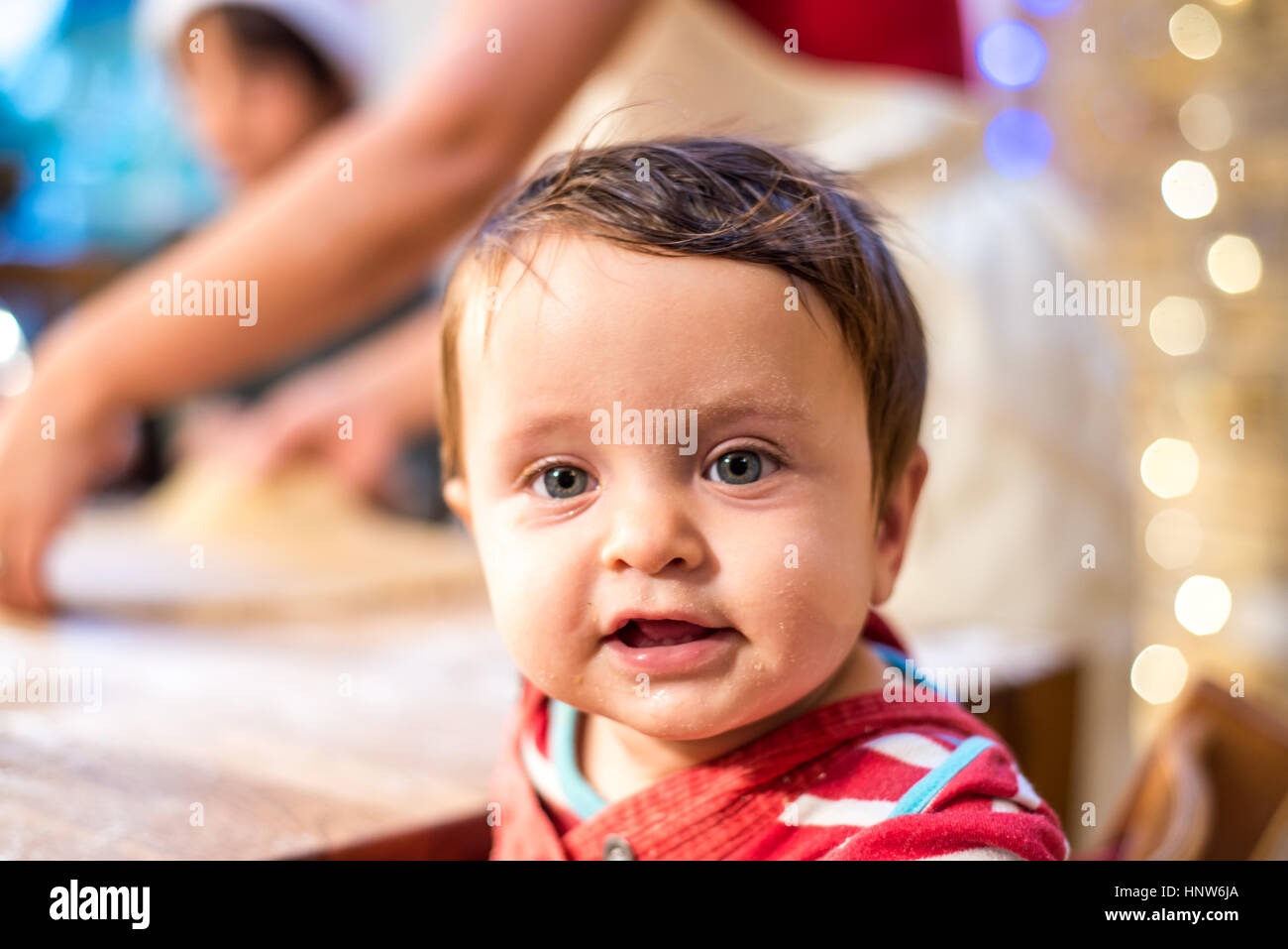 Portrait of baby boy, family in background Stock Photo - Alamy