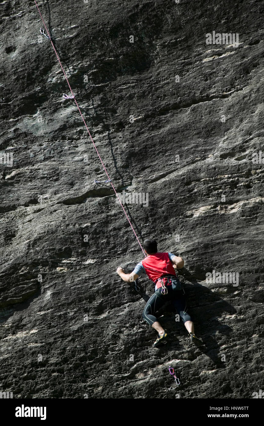 Rock climber climbing rock face Stock Photo - Alamy