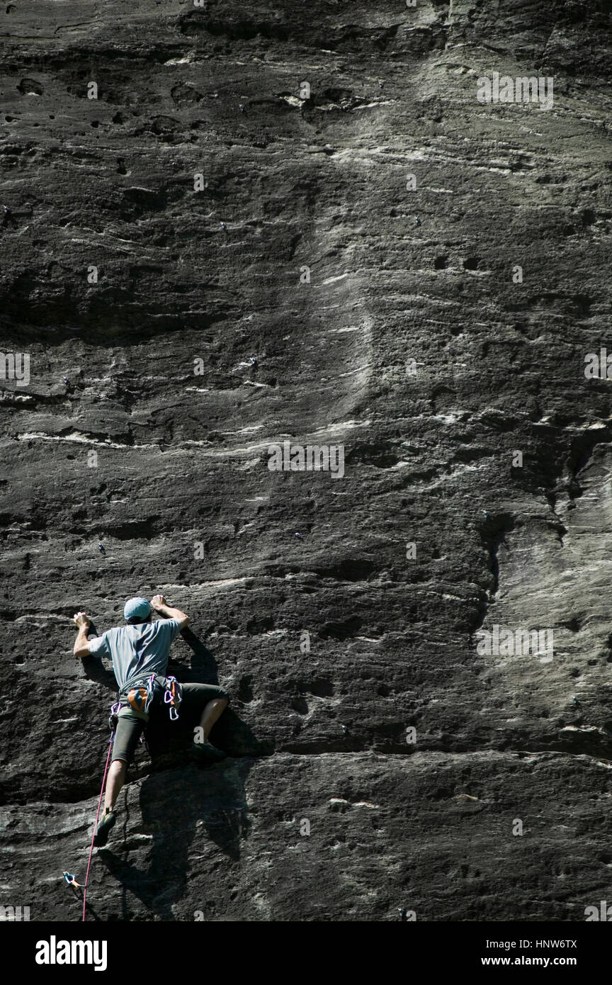 Rock climber climbing rock face Stock Photo - Alamy