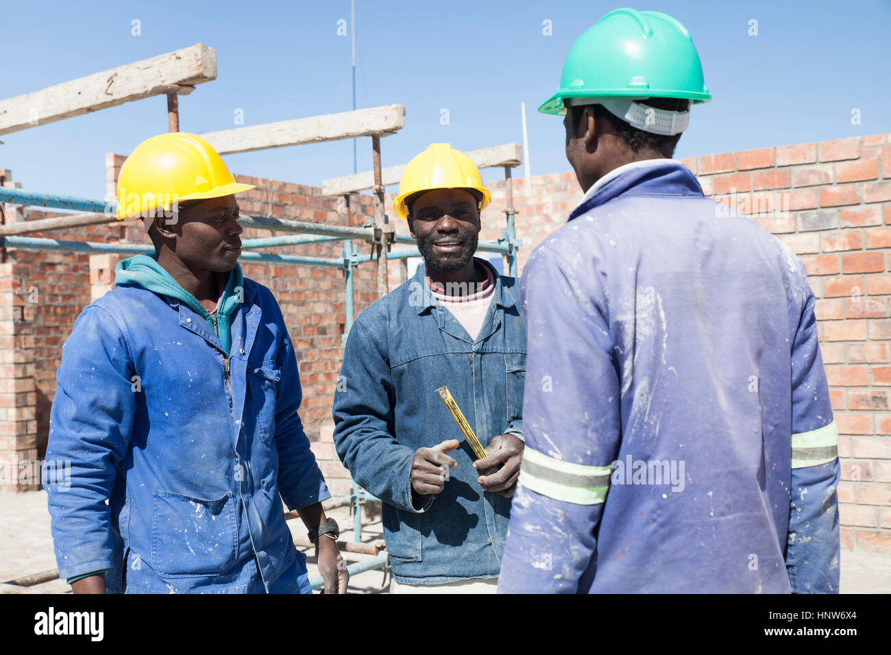 Builders talking on construction site Stock Photo - Alamy