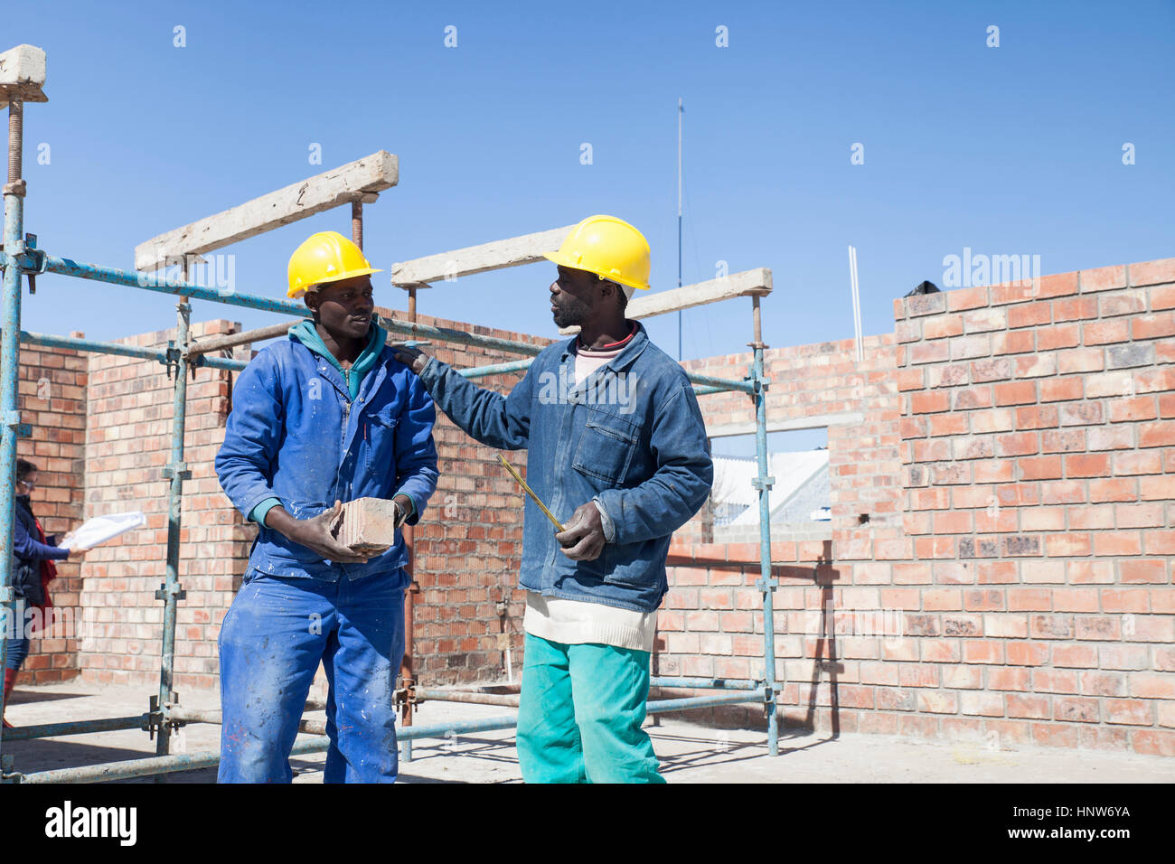 Builders talking on building site Stock Photo - Alamy