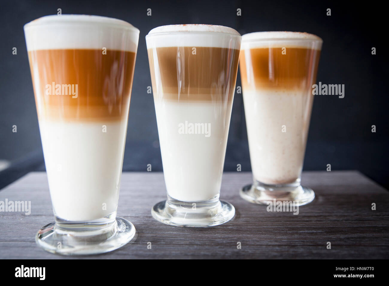 Three glasses of latte macchiato on table Stock Photo - Alamy