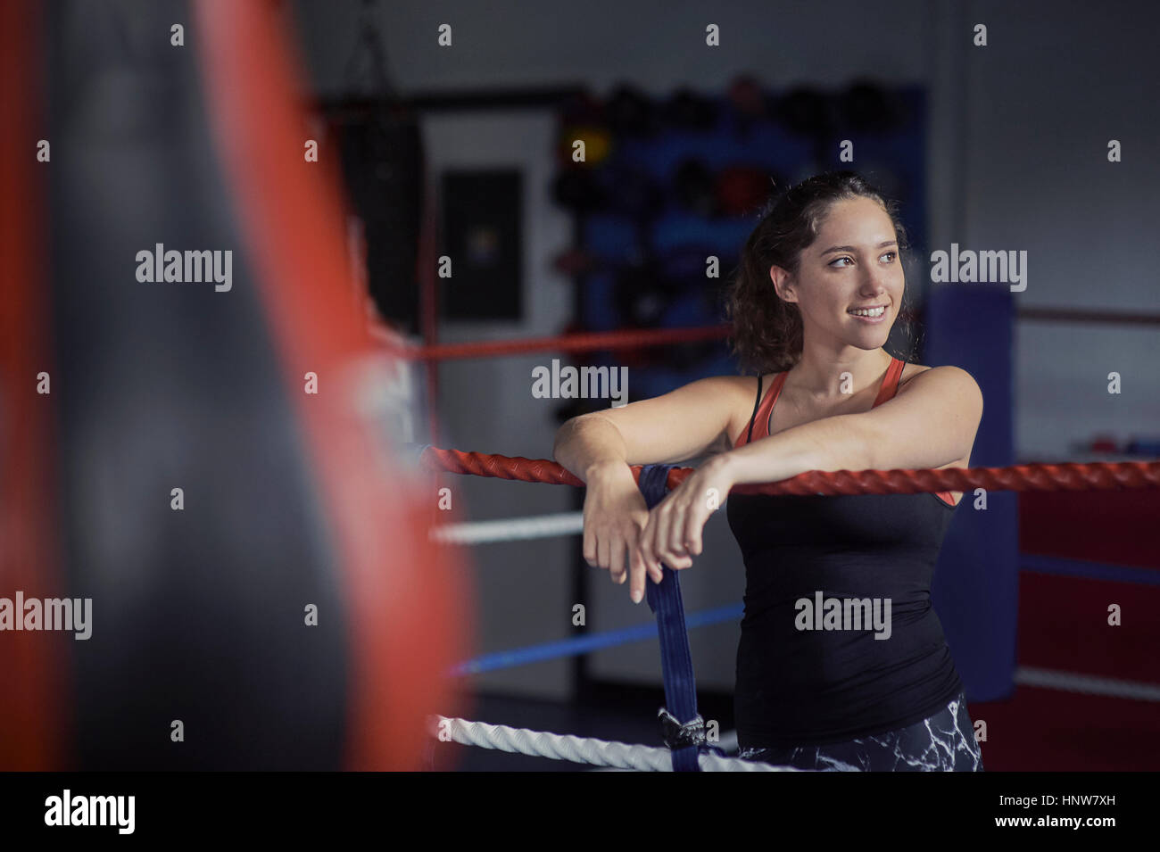 Young female boxer leaning on boxing ring ropes Stock Photo - Alamy