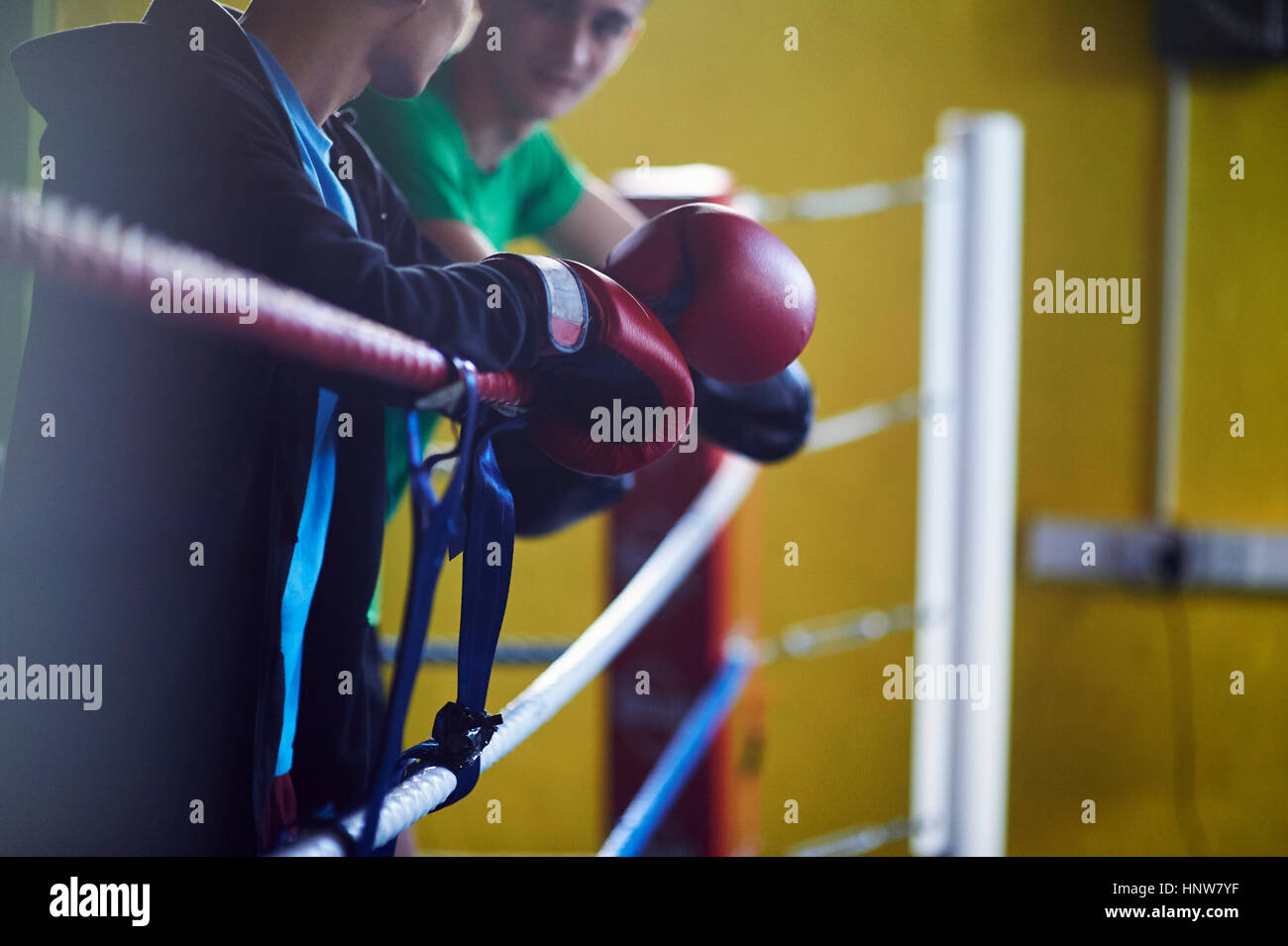 Young male boxers leaning against boxing ring ropes Stock Photo - Alamy