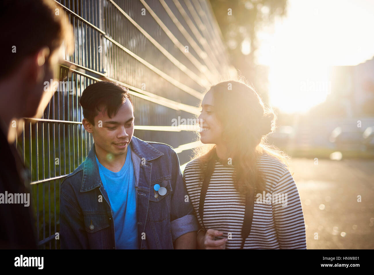 Young adult friends talking on sunlit street Stock Photo - Alamy