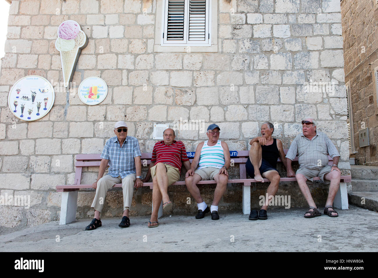 Portrait of five senior men sitting on town square bench Stock Photo ...