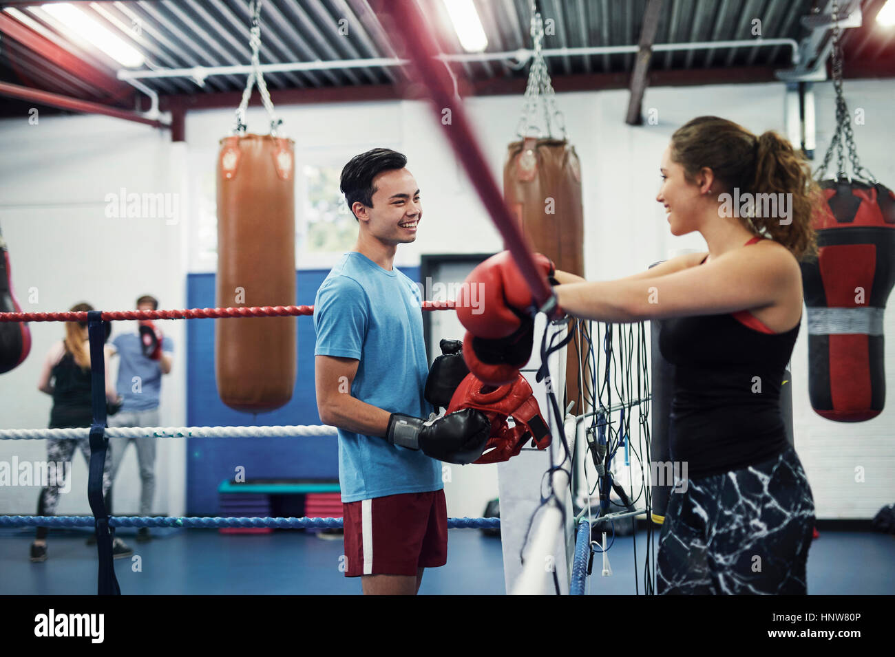 Female boxer leaning on boxing ring ropes talking to male boxer Stock ...
